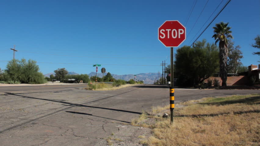 Stop Sign On Side Road As Traffic Moves By - People Driving Their Cars ...