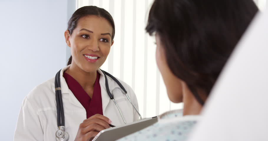 Female Doctor Talking To Hispanic Patient With Tablet Computer Stock ...